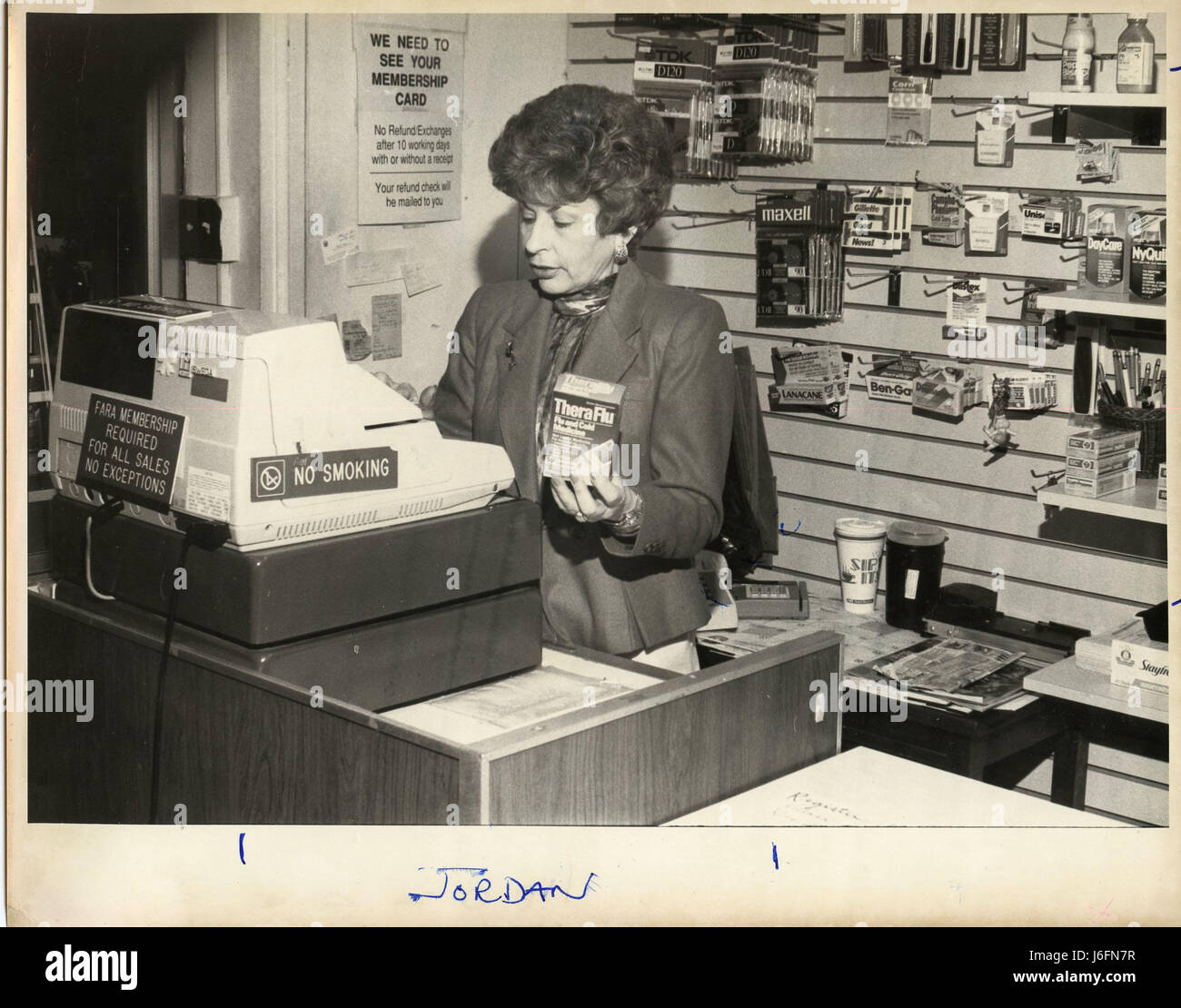 A WOMEN WORKING AT THE CASH REGISTER HOLDING A BOX OF THERA FLU Stock ...