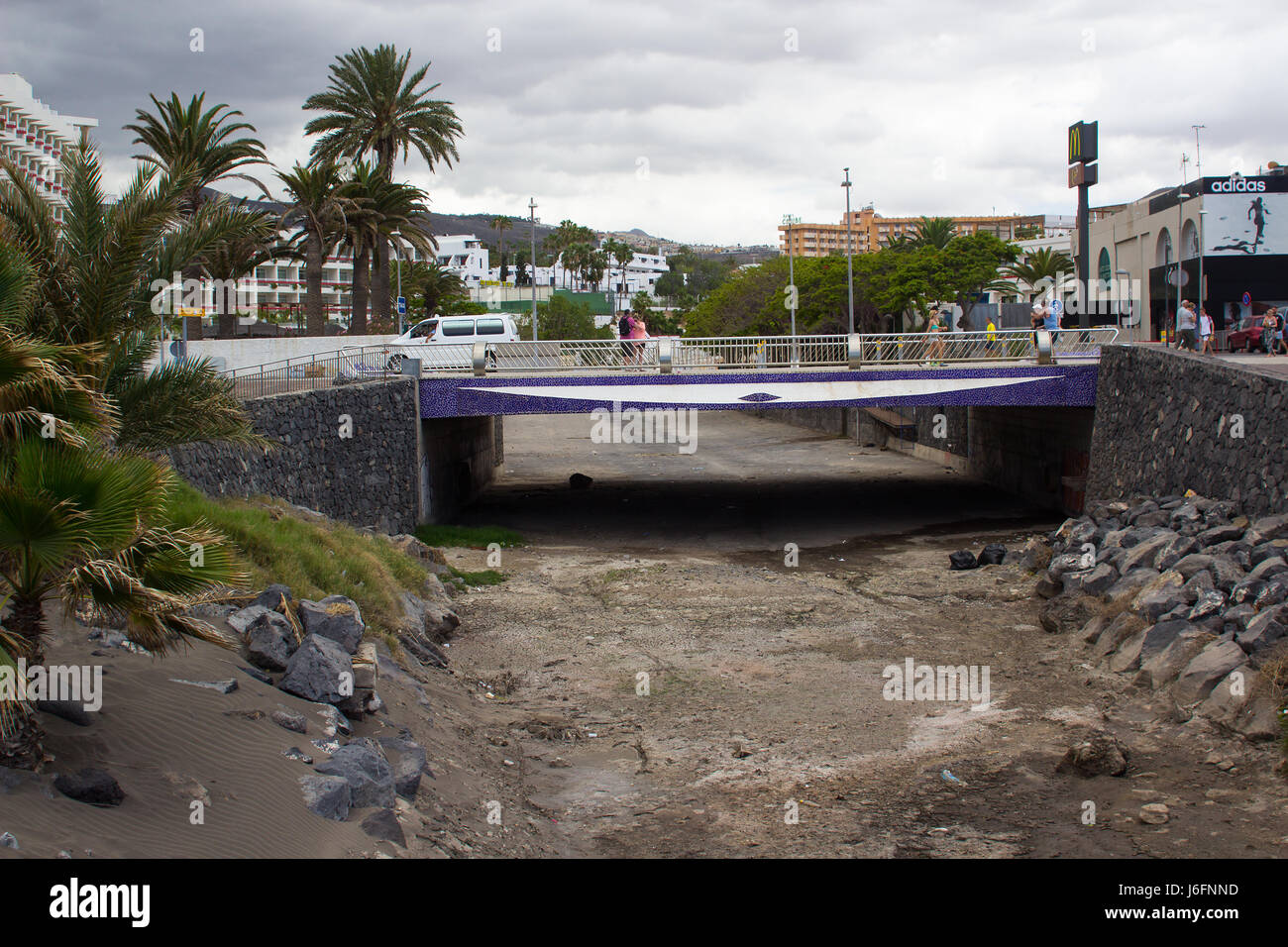 A footbridge across the dry river bed and fllood defense channel in ...