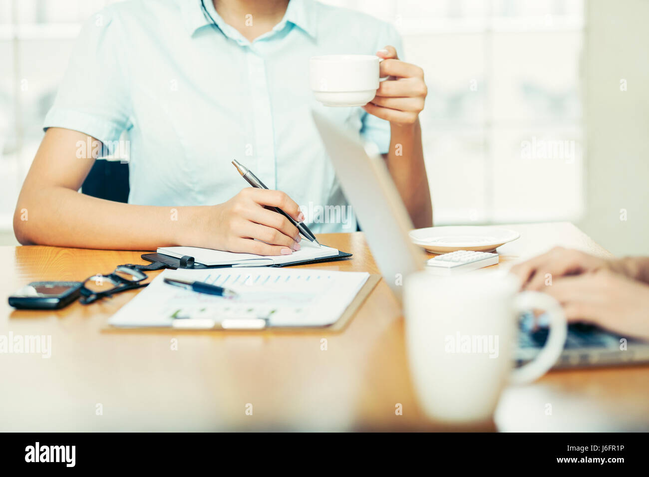 Woman hand writing on her notepad Stock Photo - Alamy