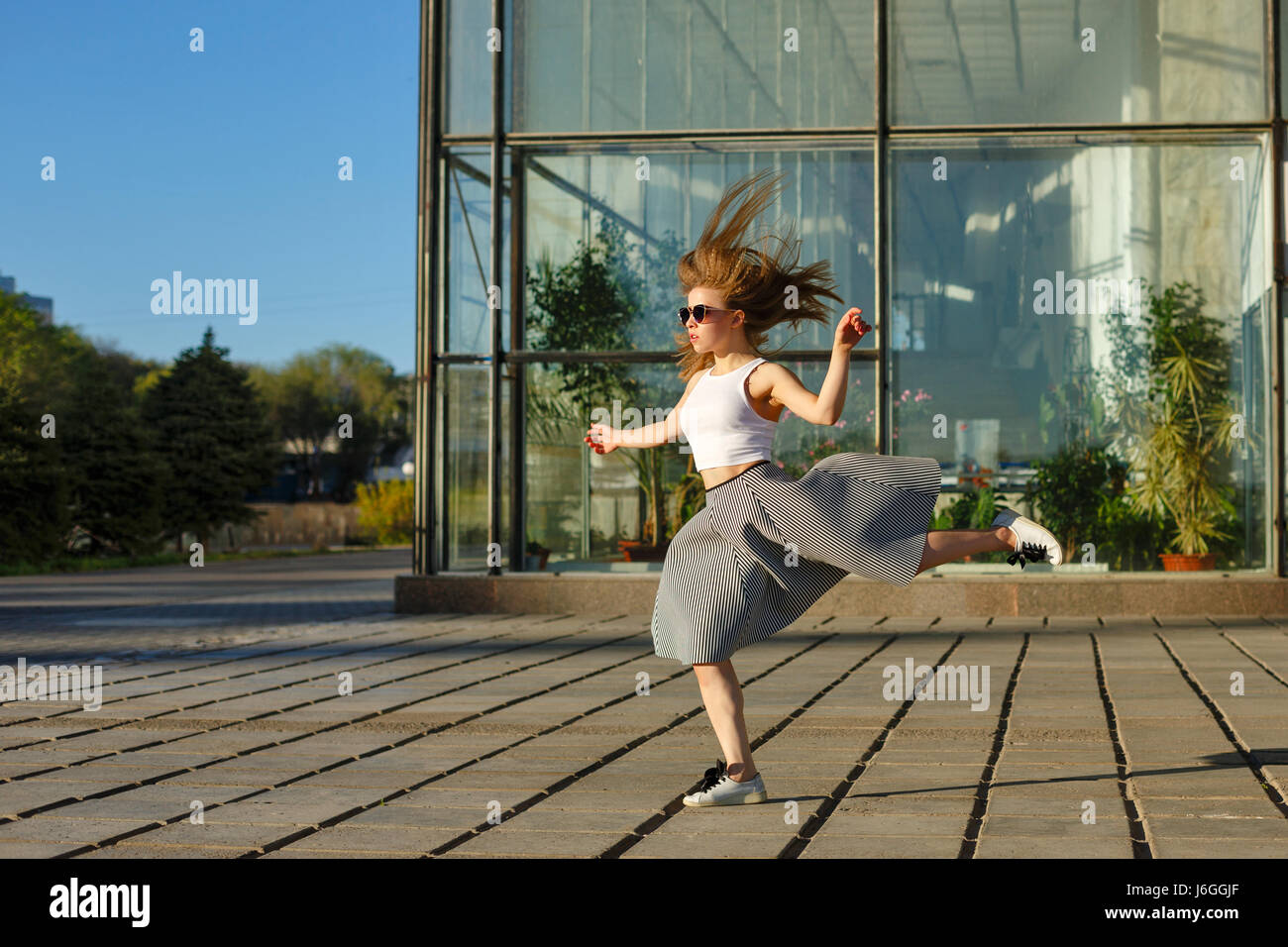 Young attractive hipster girl running. Hair fluttering. She is dressed ...