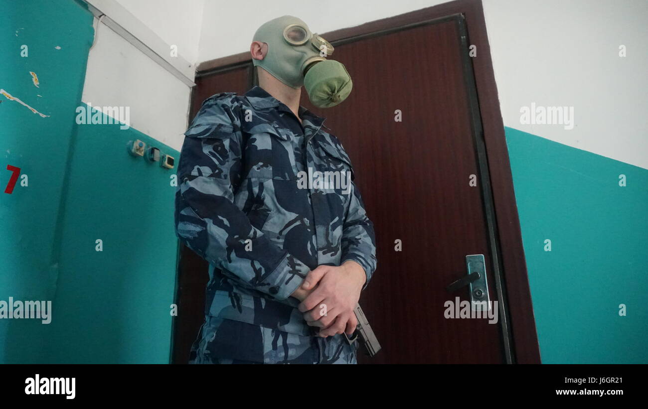 Guard dressed in military uniform in a gas mask Stock Photo - Alamy