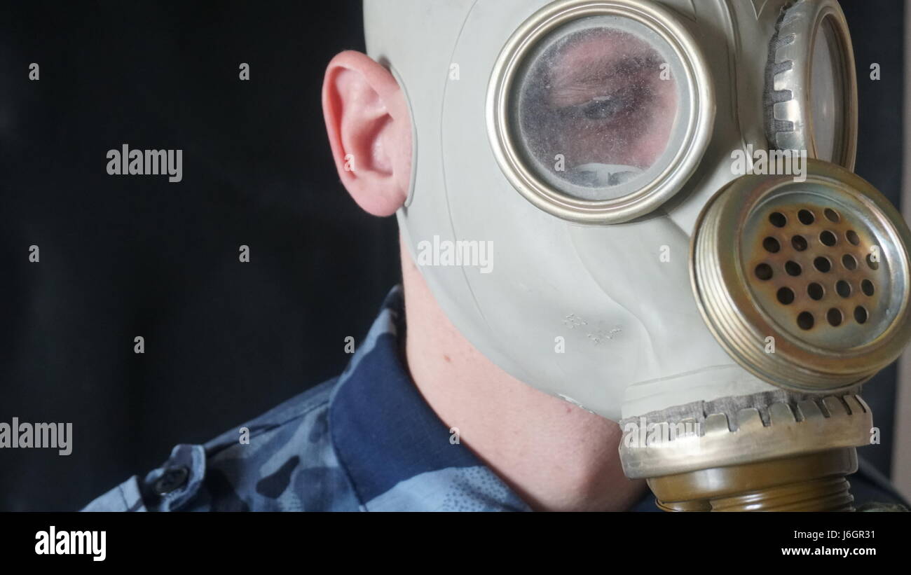 Guard dressed in military uniform in a gas mask Stock Photo - Alamy