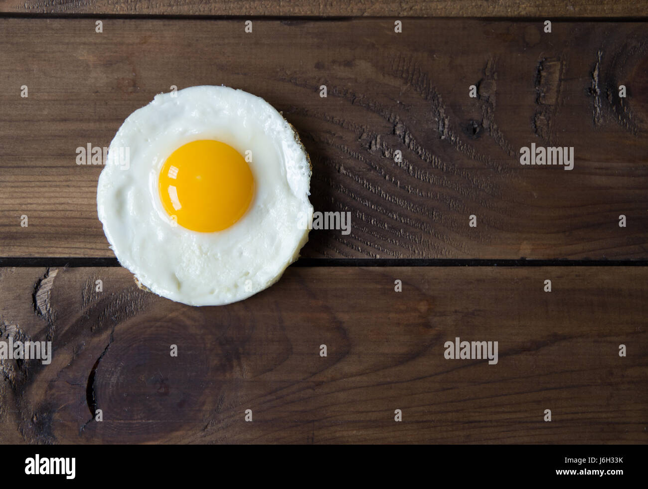round shaped fried egg for healthy breakfast on dark wooden backgrond ...