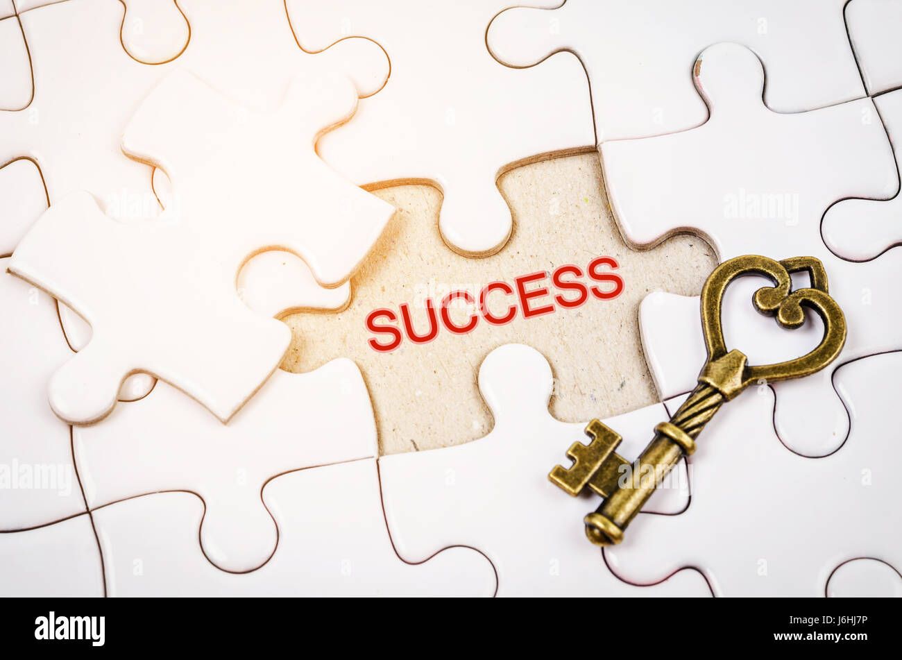 Vintage key with Success word on white jigsaw puzzle. Success business ...