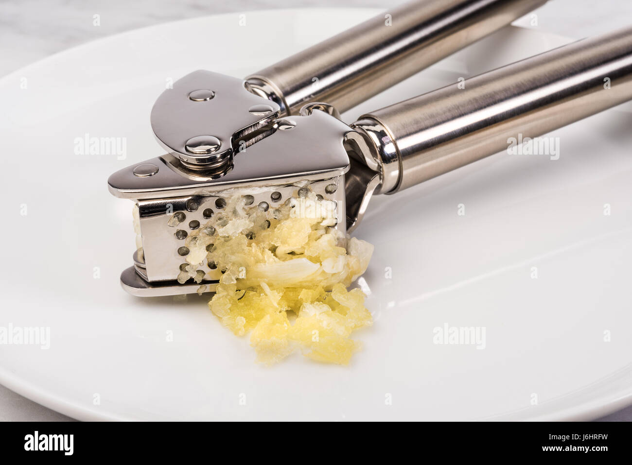 squeeze garlic Fresh French garlic and press Stock Photo - Alamy