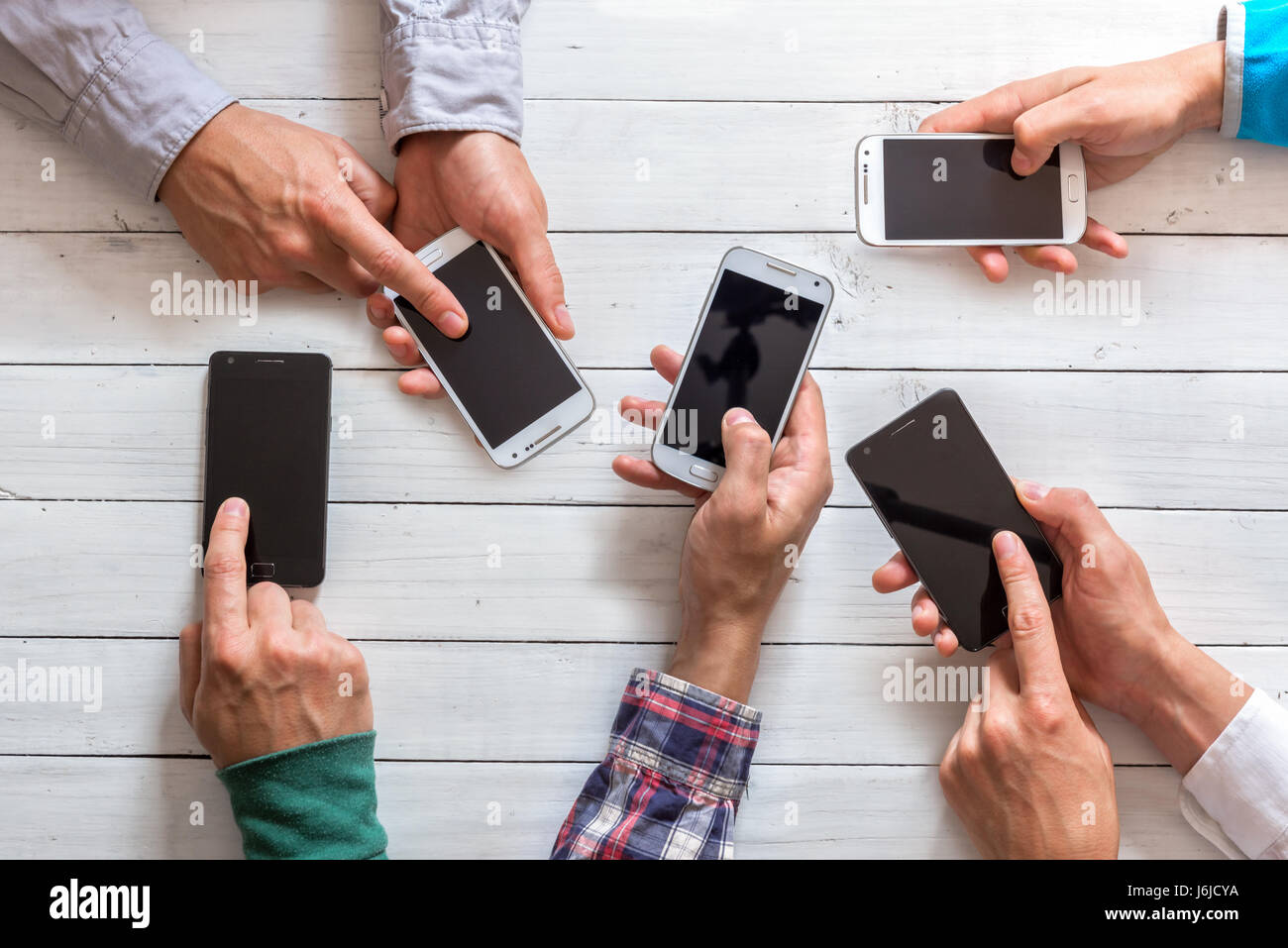 Mobile phones in friends hand closeup. Network addicted concept Stock ...