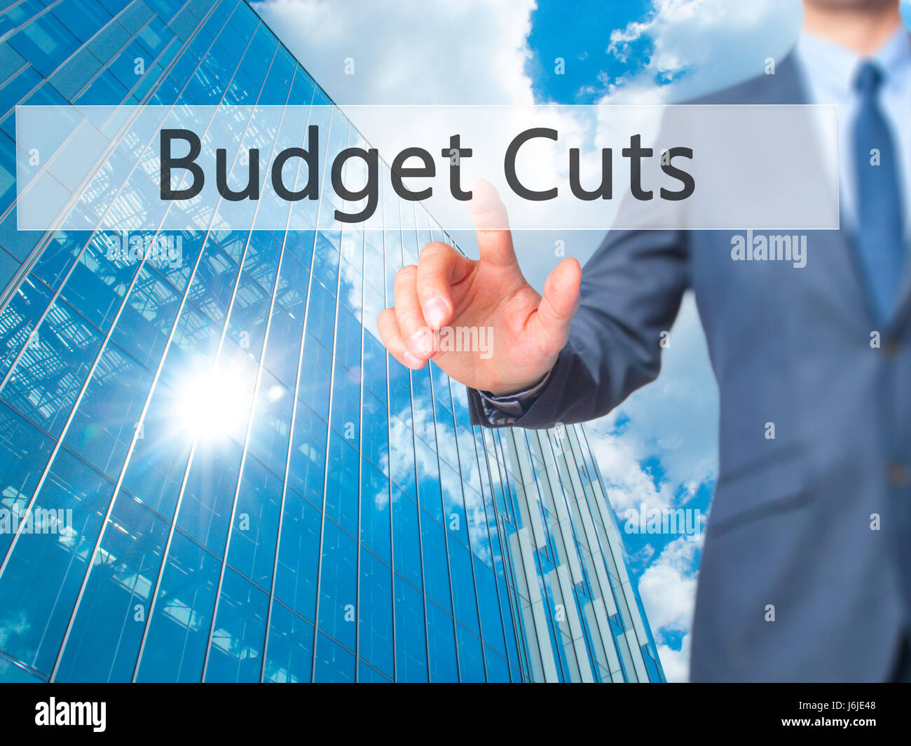 Budget Cuts - Businessman hand touch button on virtual screen interface ...