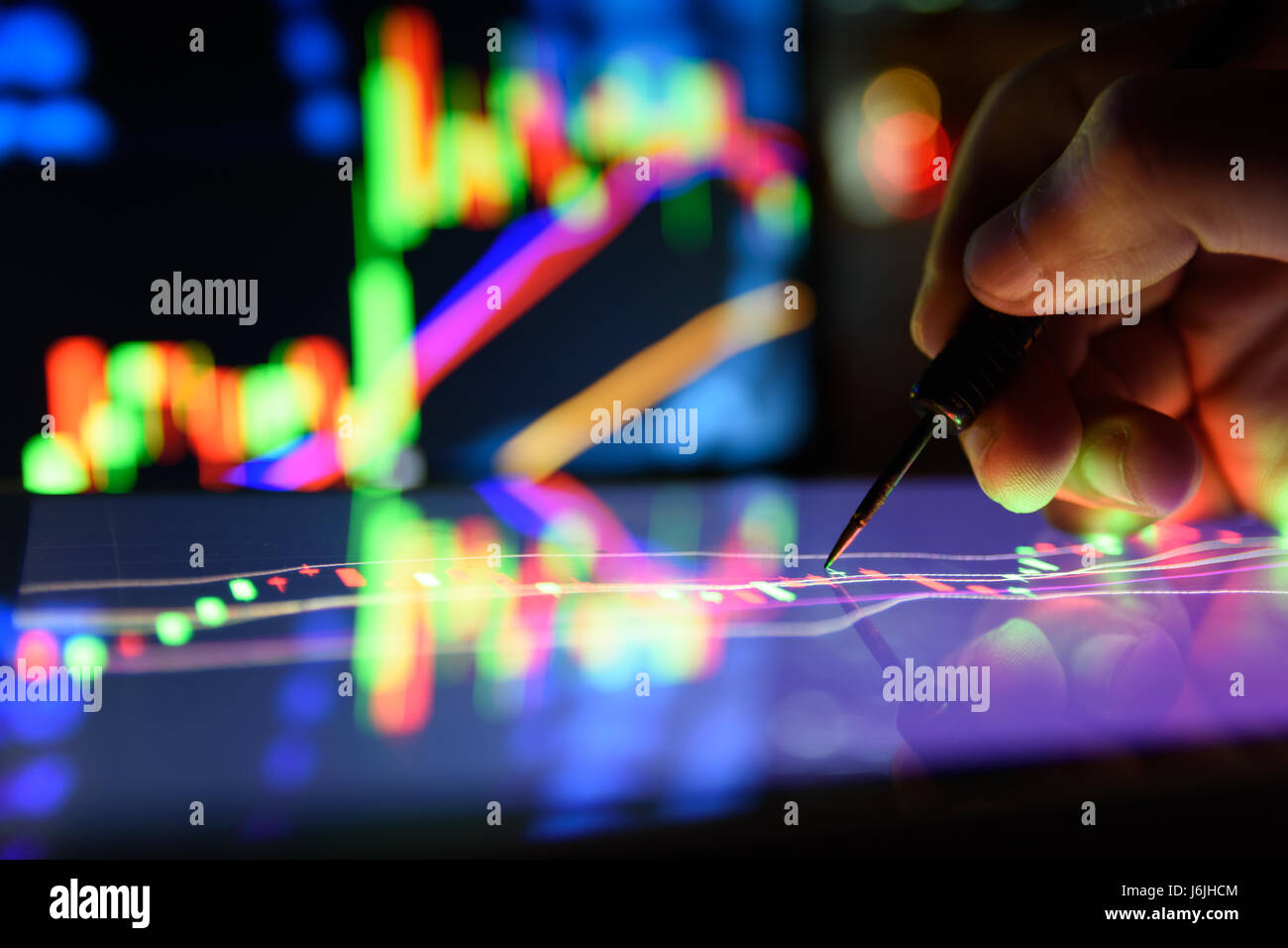 Arrow dart and man finger with Graph Stock market trading tablet screen ...
