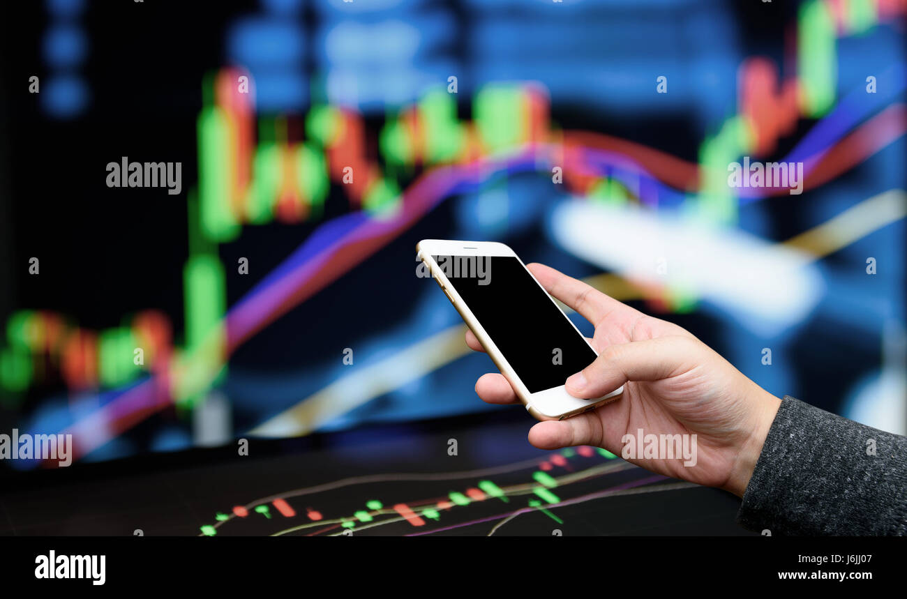 Hand holding mobile smartphone with abstract stock market graph digital ...