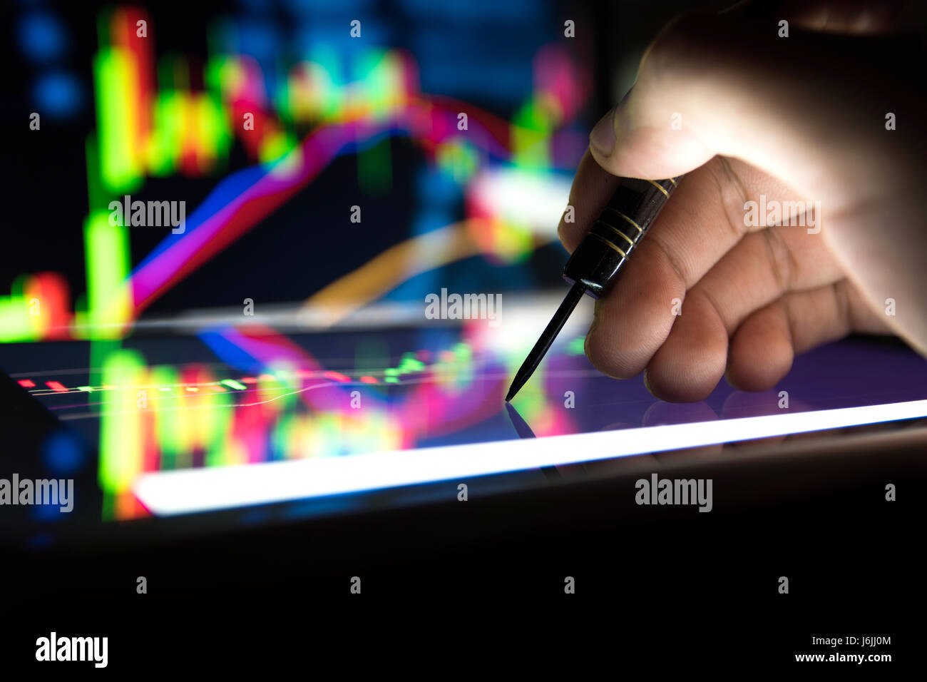 Arrow dart and man finger with Graph Stock market trading tablet screen ...