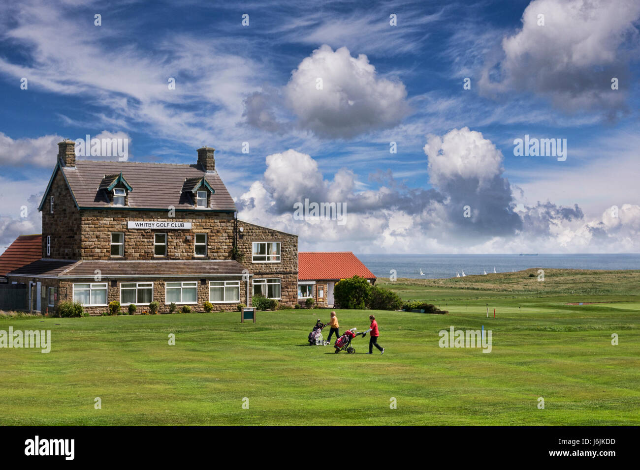 Two lady golfers walk in front of Whitby Golf Club with their golf ...