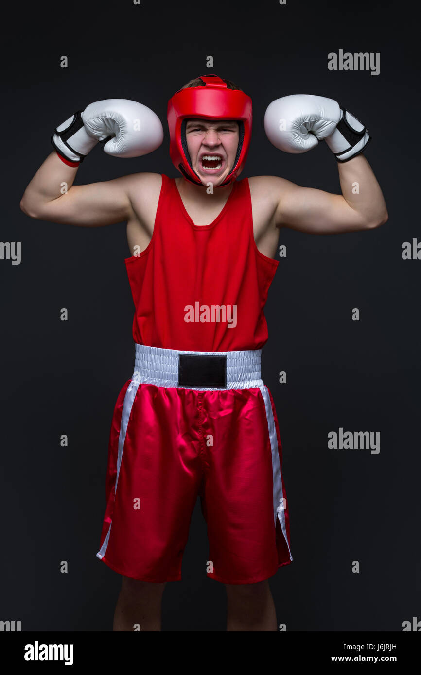 Teenage boxer in red form and white boxing gloves with hands up. Young ...