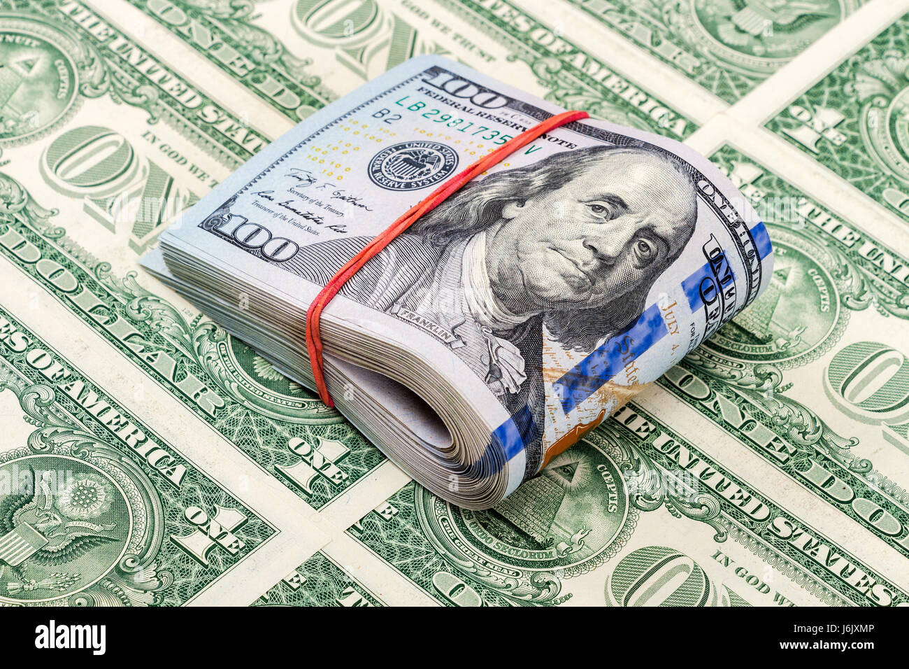 Folded american dollar bills wrapped by rubber band over dollars ...