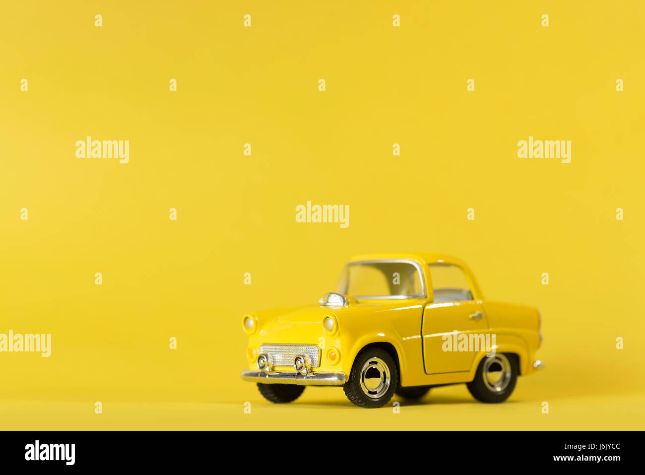 Yellow toy car on a yellow background Stock Photo - Alamy