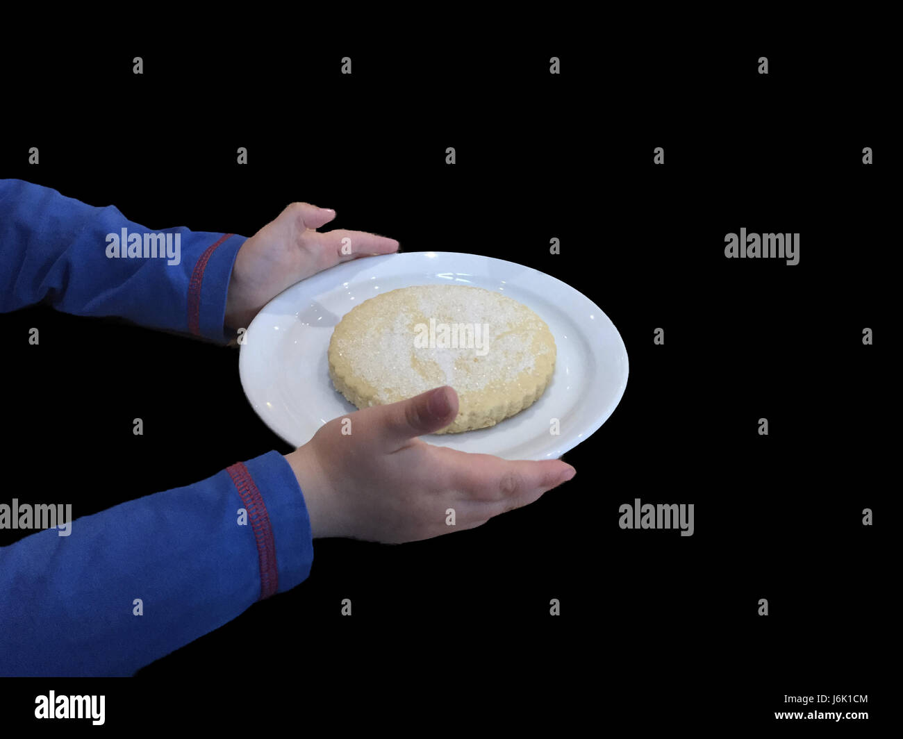 Shortbread biscuit on plate, coffee, & child's hands. Child is ready to ...