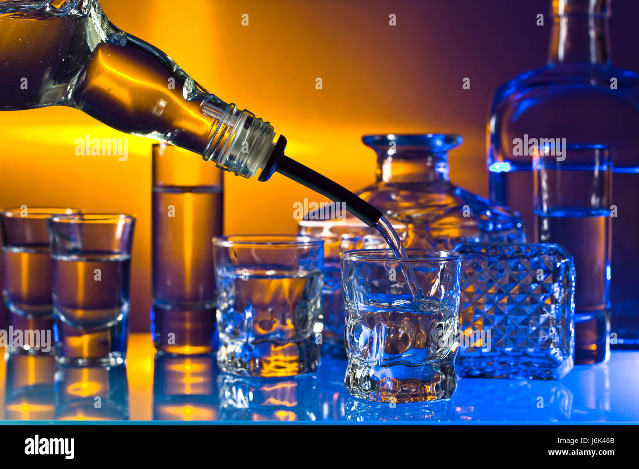 Glasses with alcoholic drinks on a glass table in bar. Focus on a ...