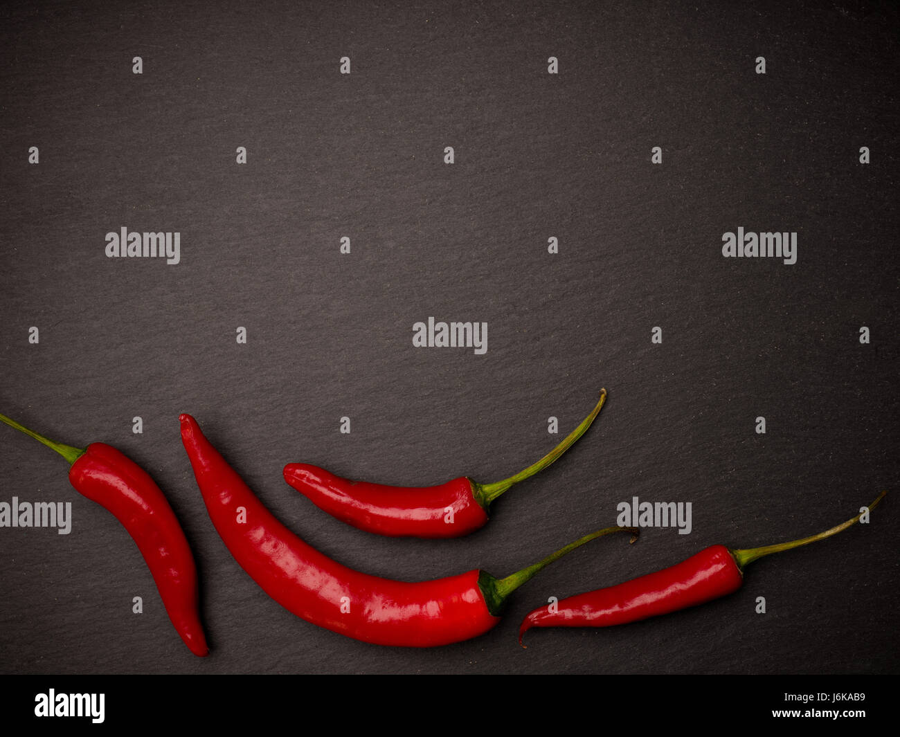 Red pepperoni on a dark slate background with space for text Stock ...