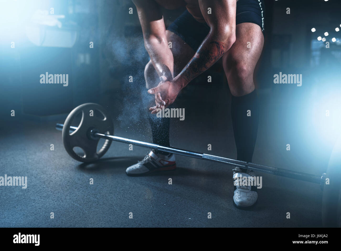 Athlete hands in powder and talc, barbell exercise. Strong weightlifter ...