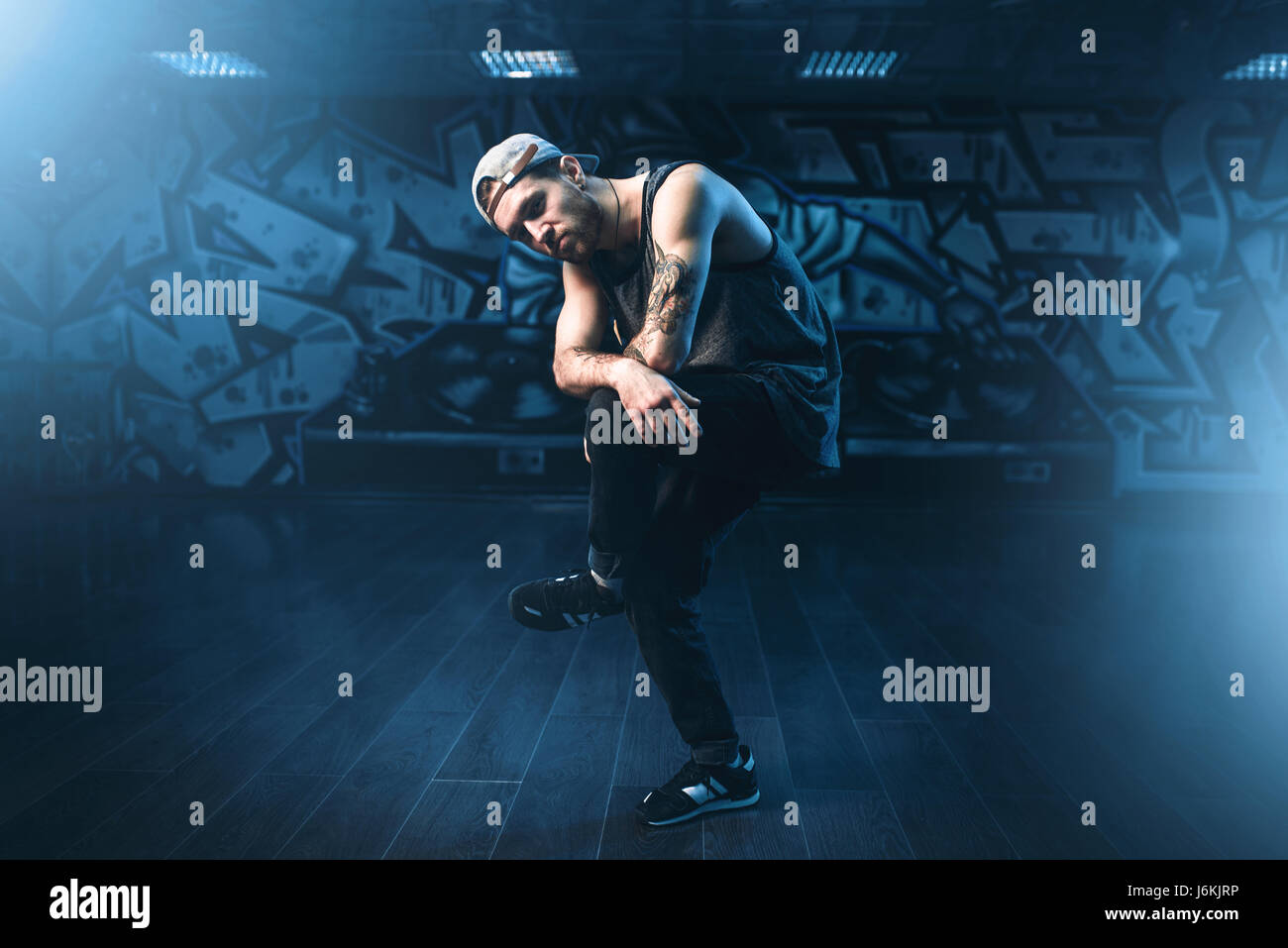 Young male hip hop dancer posing in dance studio. Modern urban dancing ...