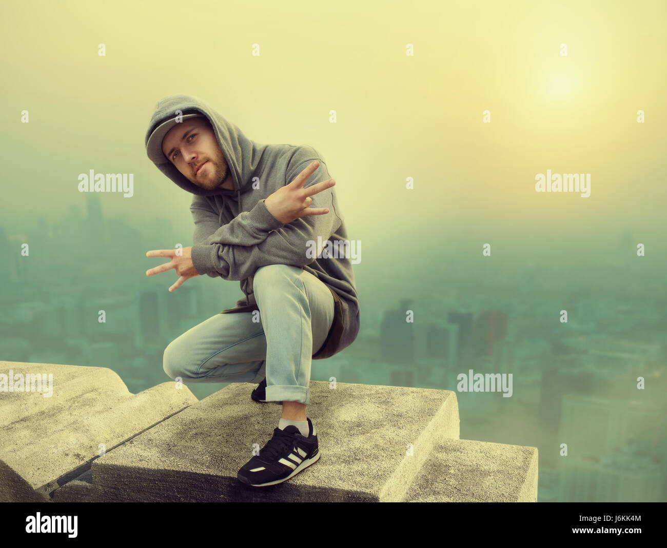 Hip hop performer posing, cityscape on background. Modern dance style ...
