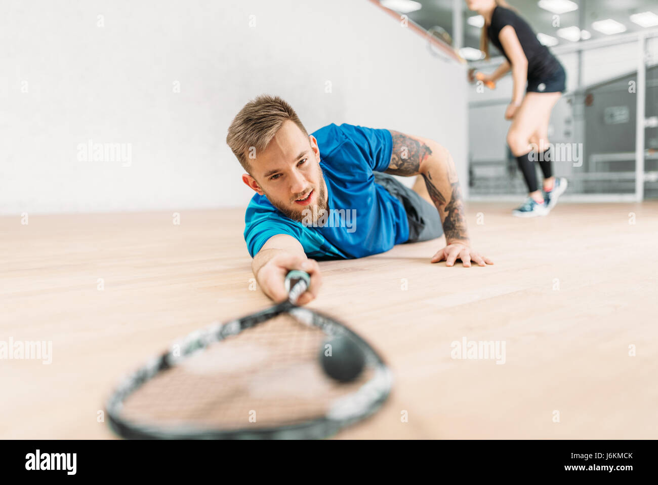 Squash training, male player with racket lies on the floor. Active ...