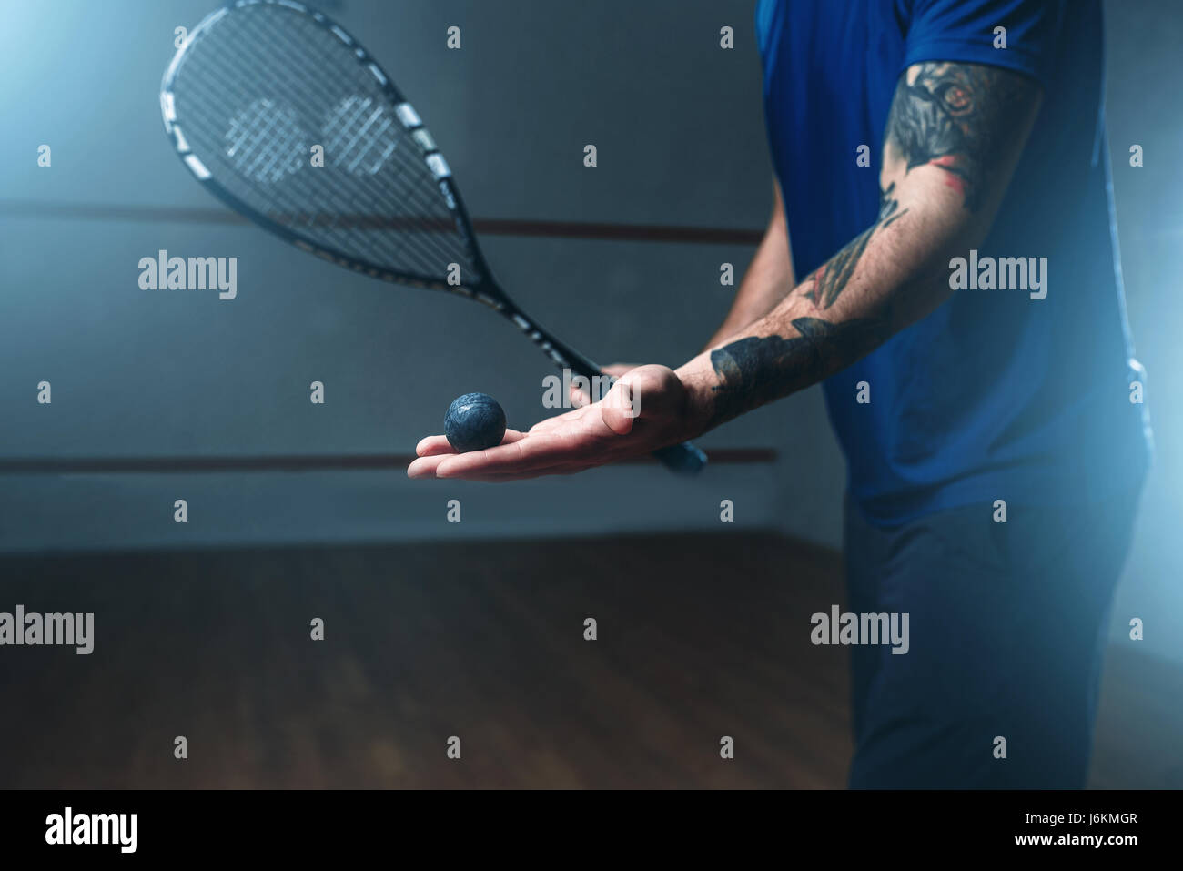 Male squash player with racket training on indoor court. Active sport ...