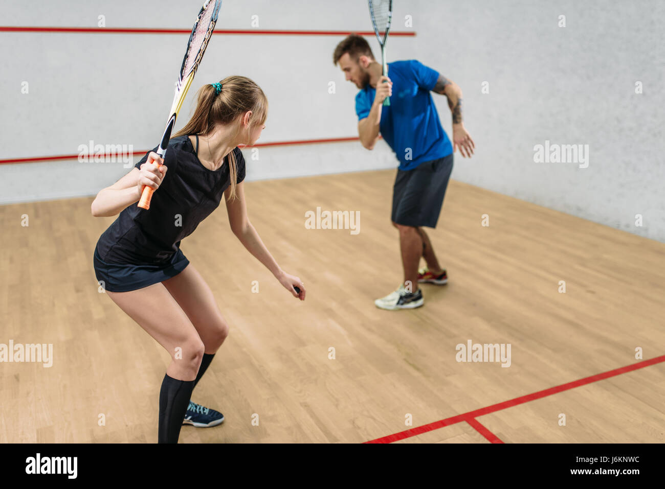 Young couple with squash rackets, indoor training club. Active sport ...