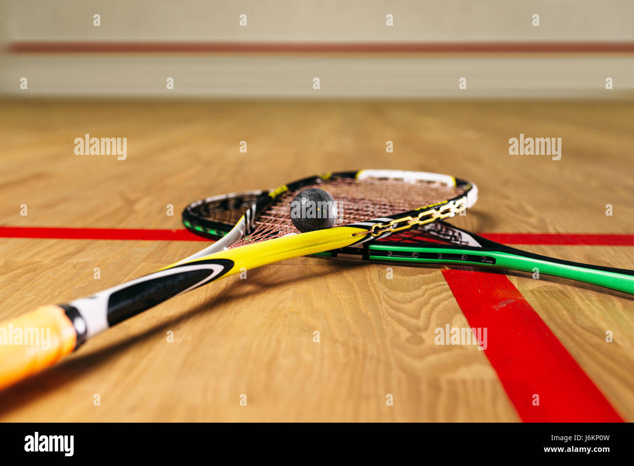 Squash game equipment closeup view. Rackets and ball on the floor in ...