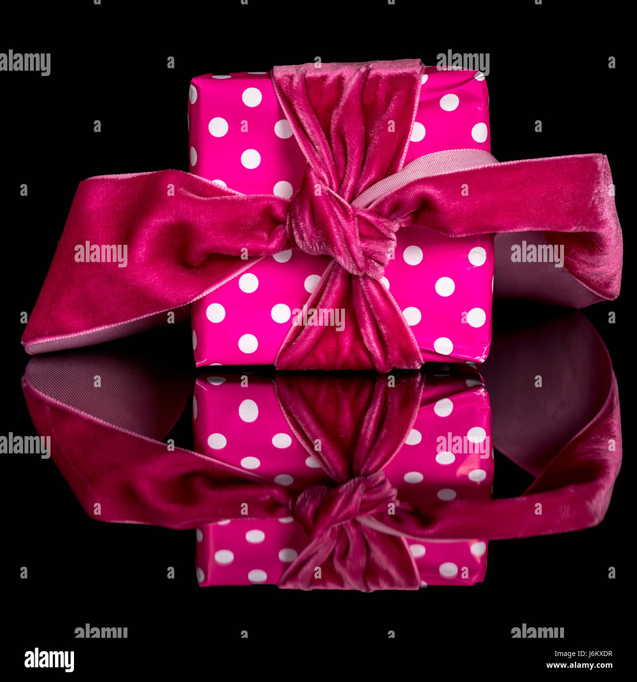 Red present with a bow and reflection Stock Photo - Alamy