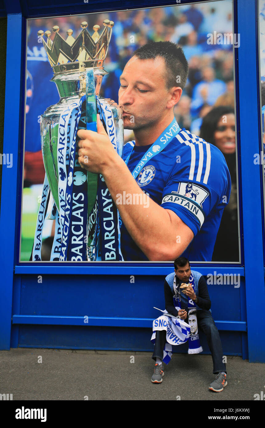 A fan eats lunch under a giant John Terry poster during the Premier ...