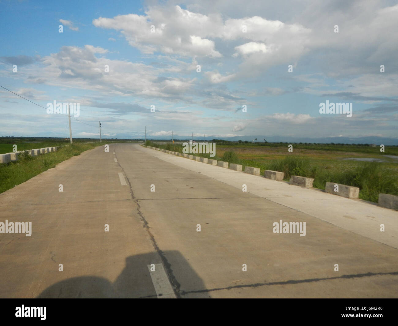 This photograph captures the landscape of paddy fields and rural roads ...