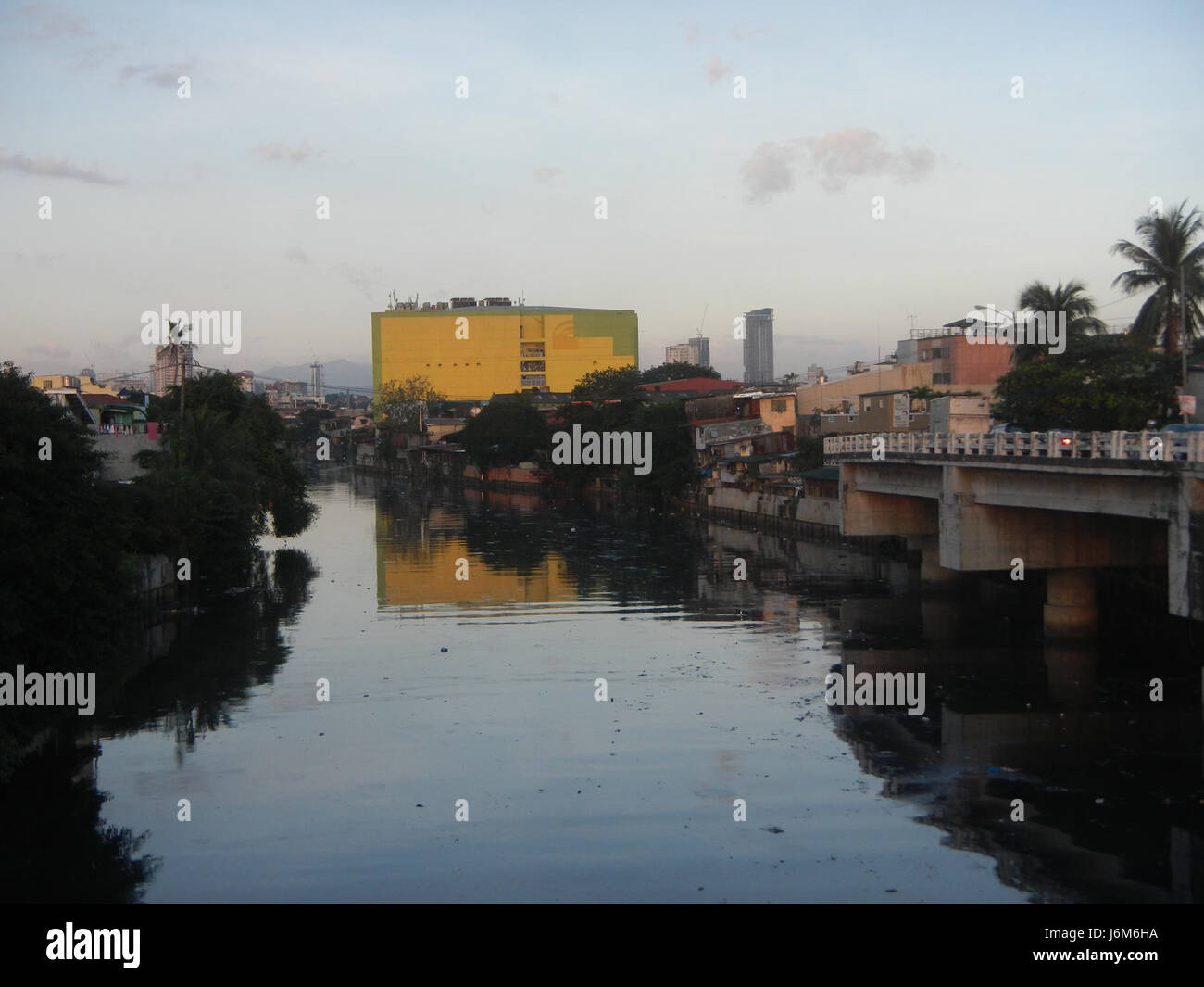 This photograph captures a sunset over the Pasig River, with views of ...