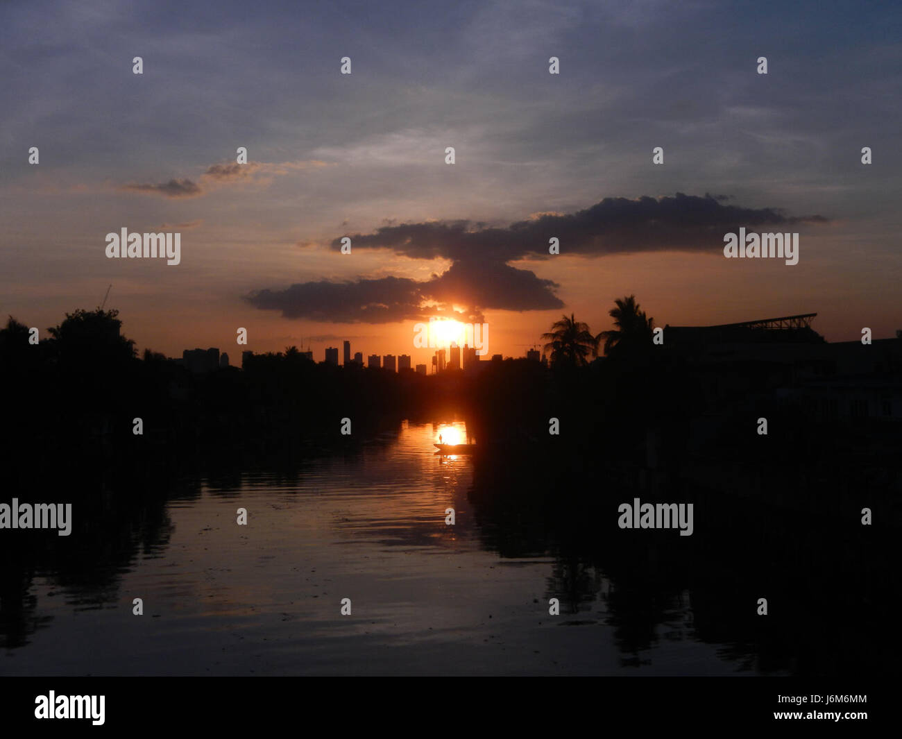This image captures a sunset over the Pasig River, with views of the ...