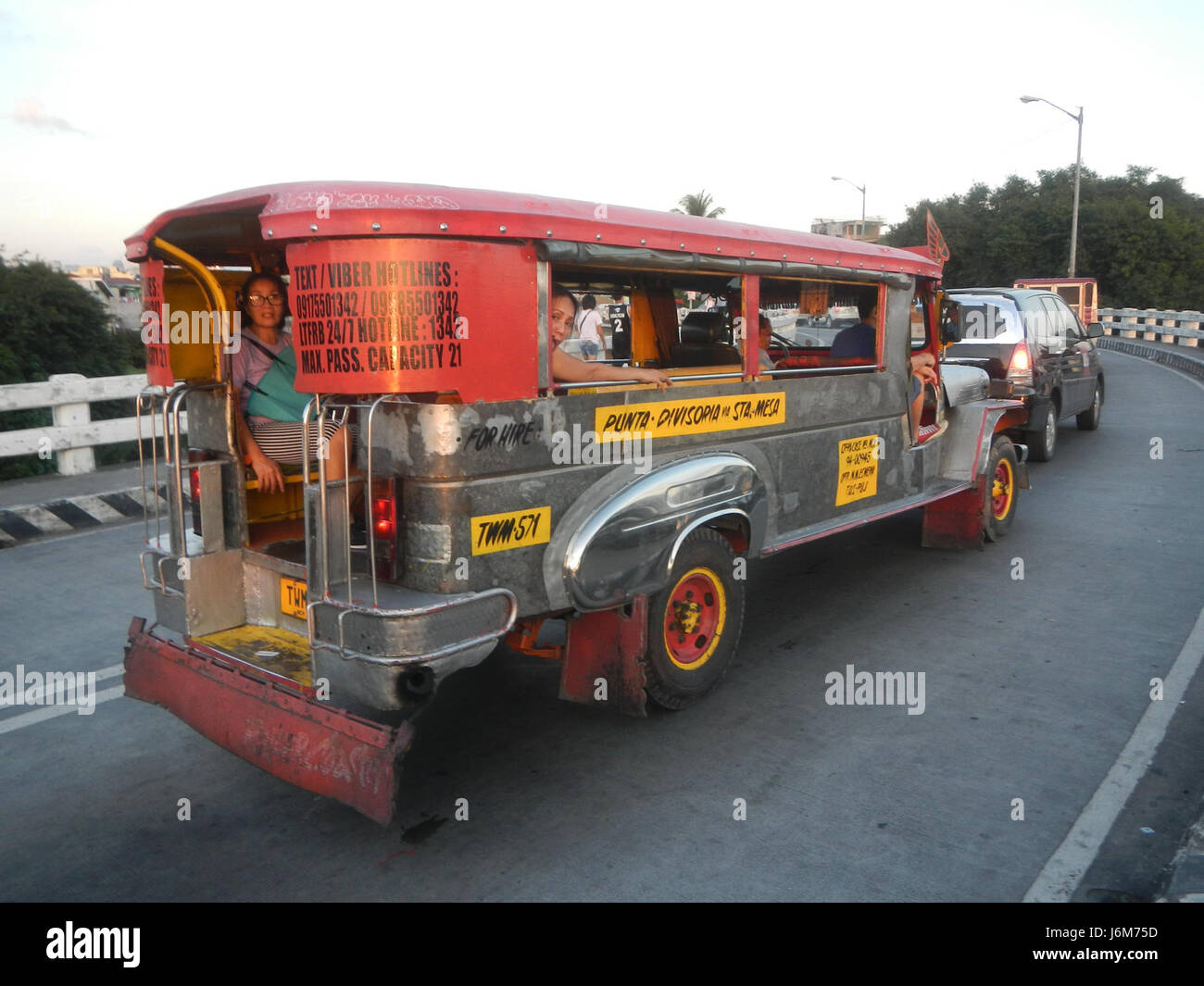 This image depicts a sunset scene along the Pasig River, passing ...
