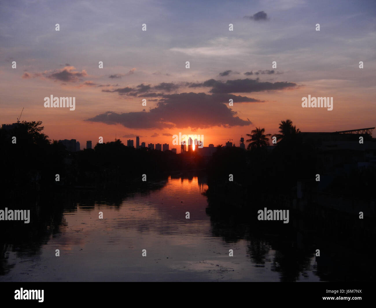 A scenic photograph capturing the sunset over the Pasig River, visible ...