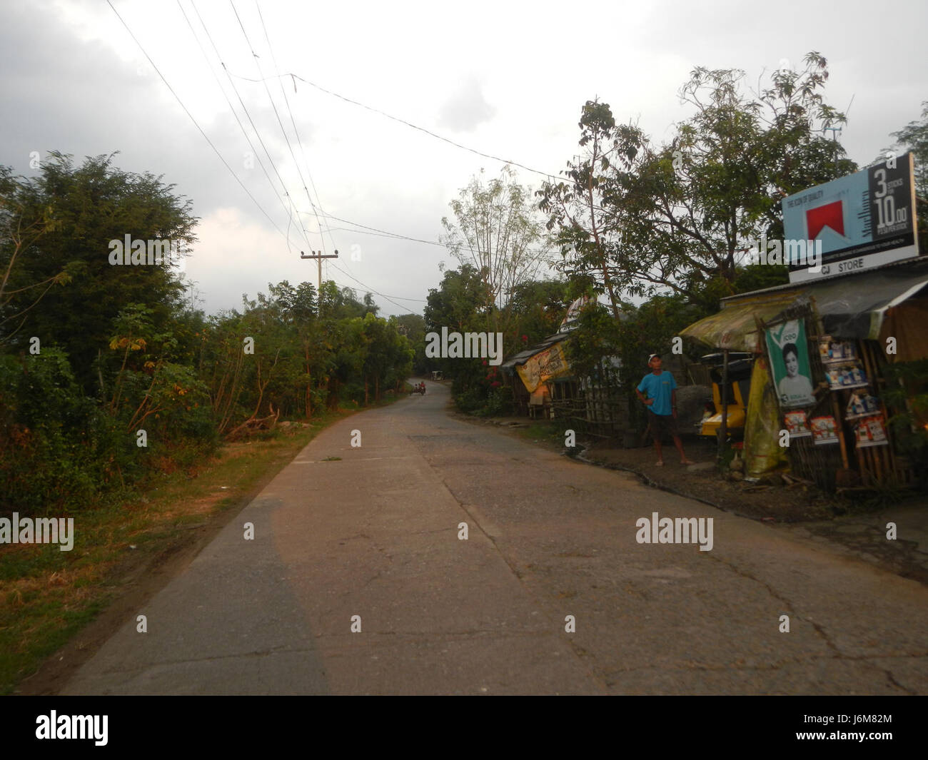 This image shows a rural road passing through paddy fields and ...