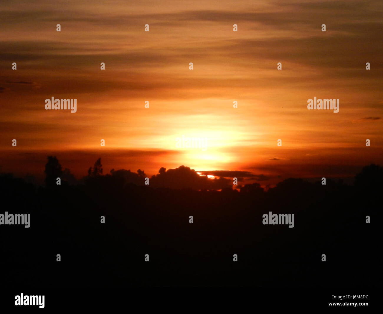 The photograph captures a vivid sunset over the towns of San Ildefonso ...