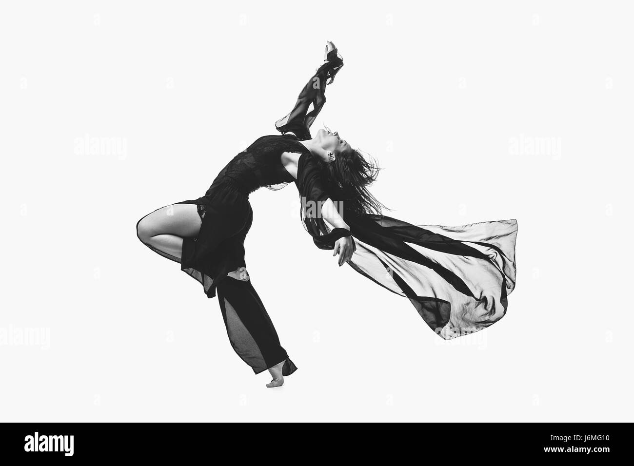 Beautiful modern dancer young woman in black flyings fabrics making ...