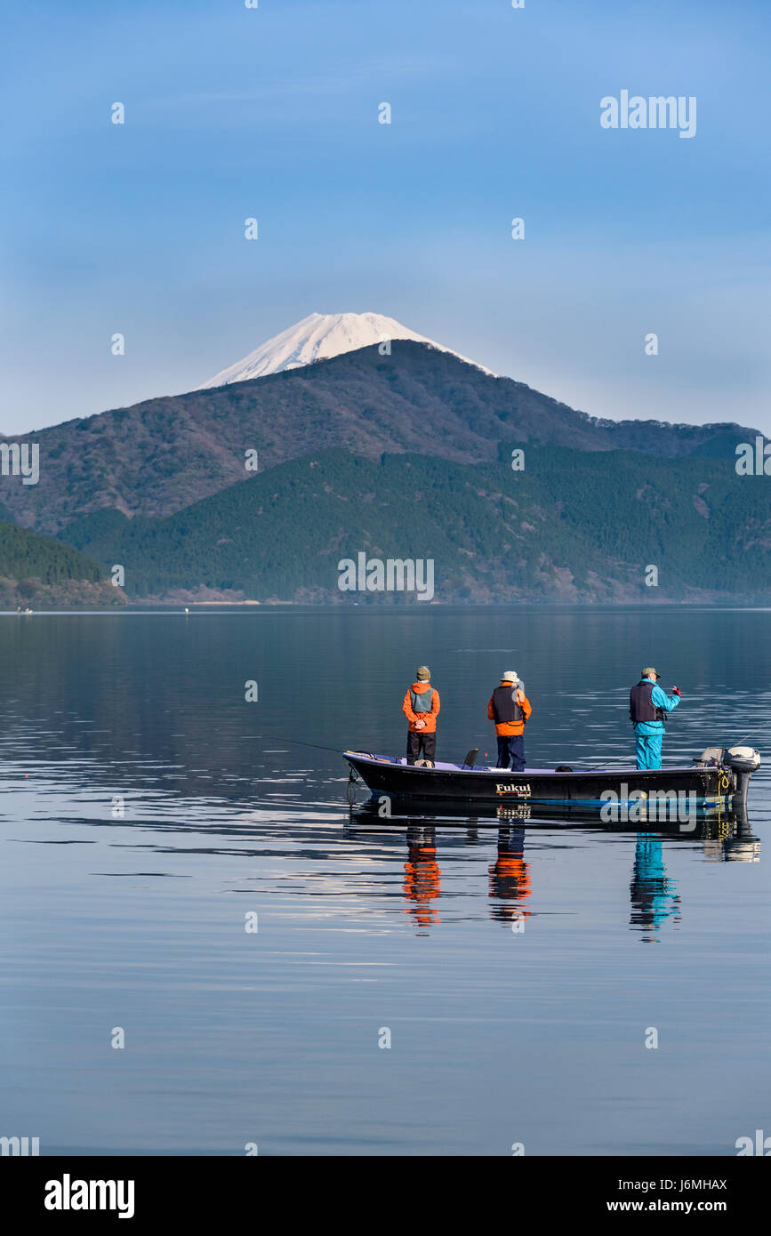 Three japanese men fishing in lake Ashinoko, with snow capped mount ...