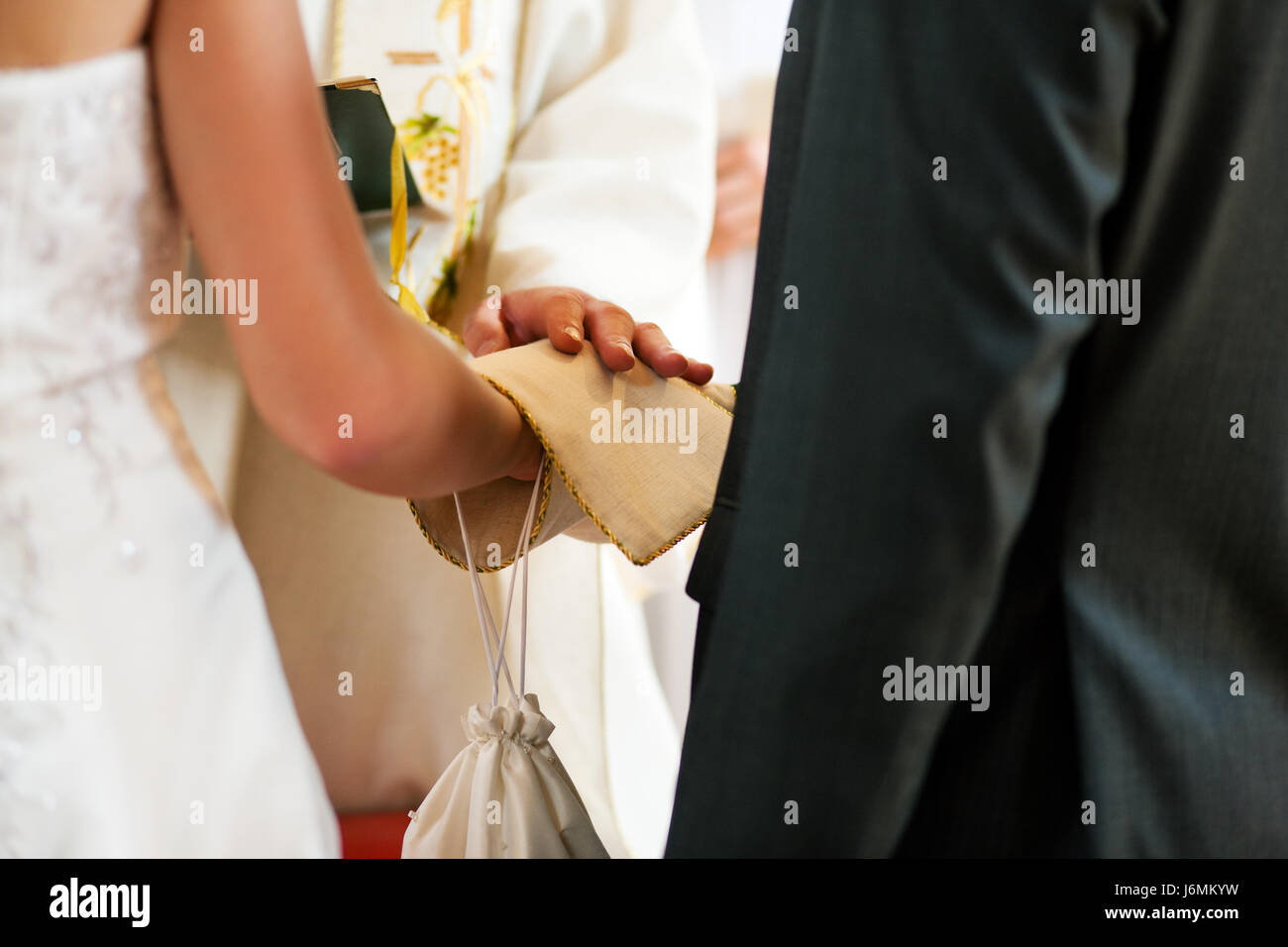 wedding couple receiving blessing from priest Stock Photo - Alamy