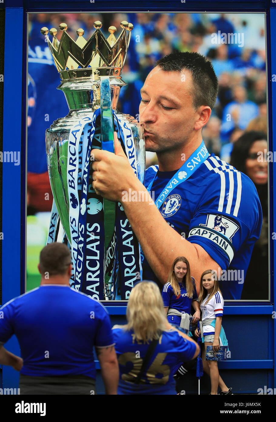 Chelsea fan's have their photo taken in front of a John Terry poster ...