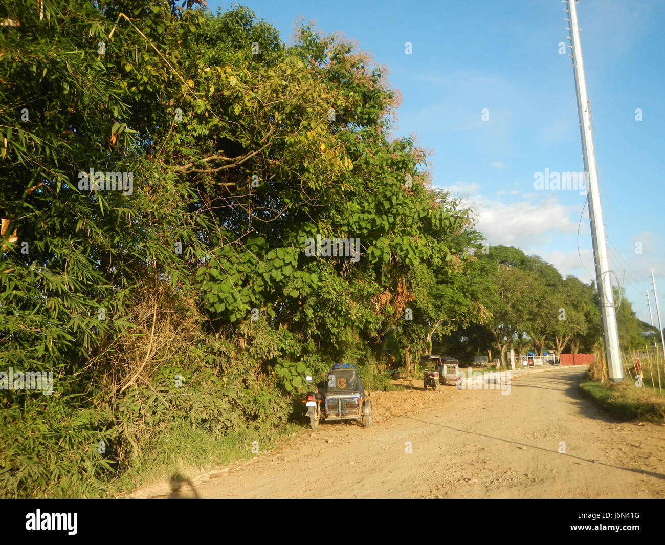 The image shows a sunset over paddy and vegetable fields in Upig ...