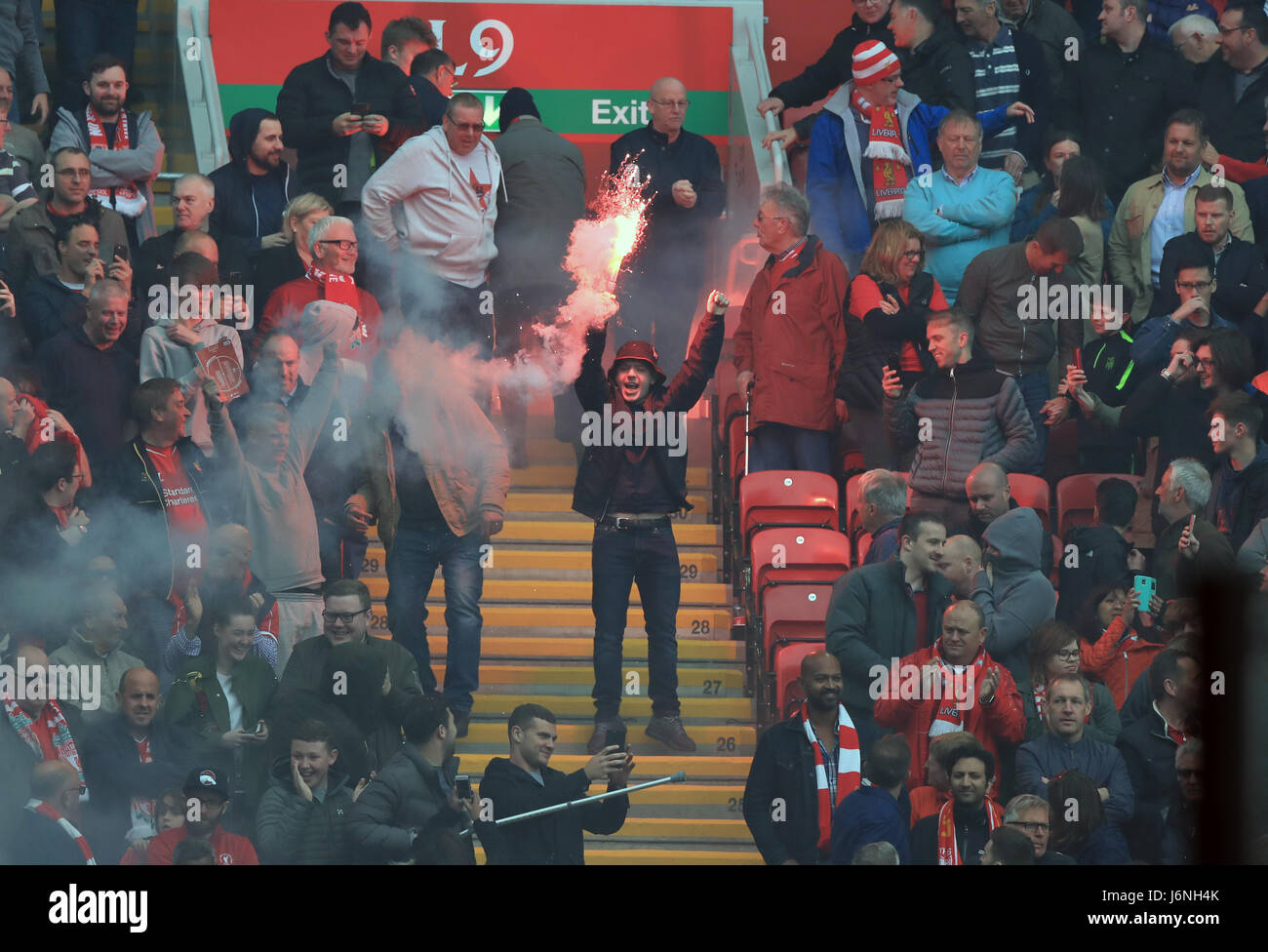 A Liverpool fan celebrates with a flare in the stands during the ...