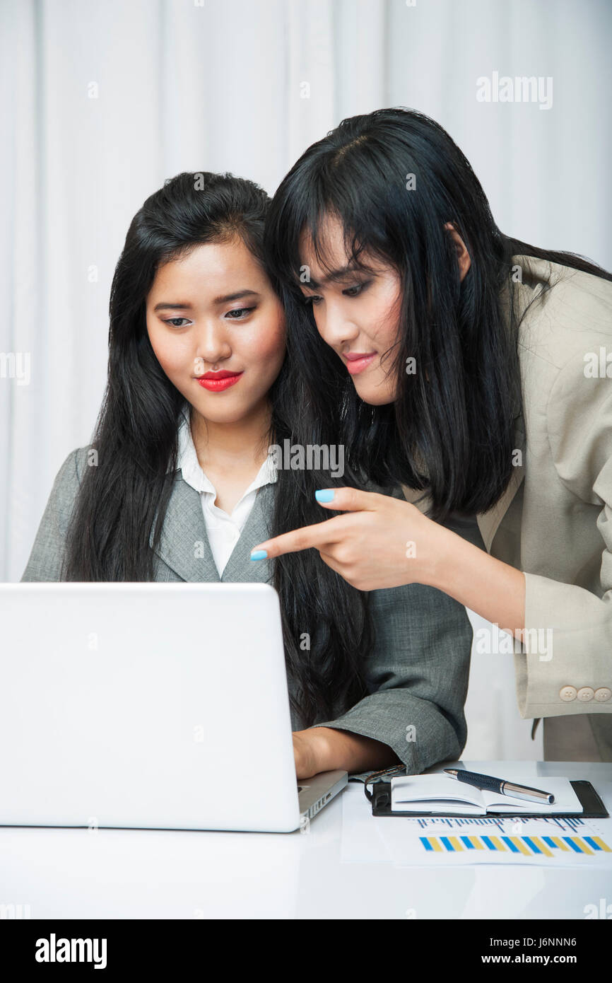 portrait image of businesswomen assistants working in front of laptop ...