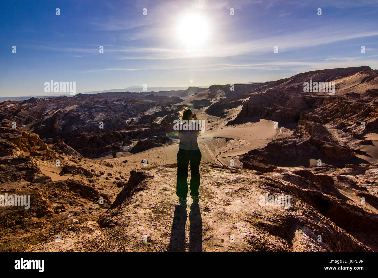 girl standing on a cliff in salty Moon valley in atacama desert at ...