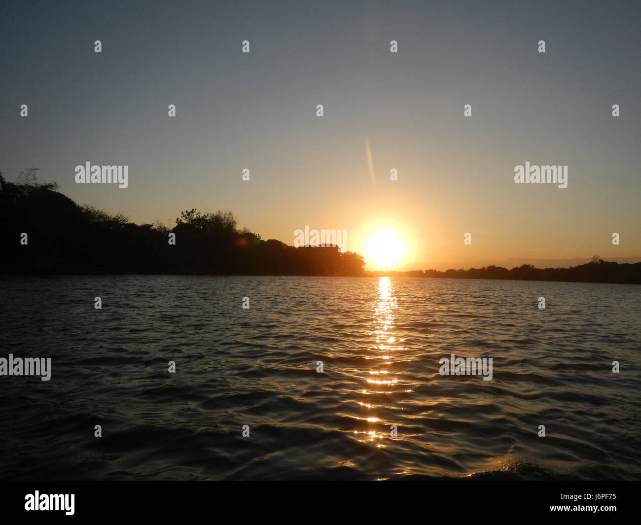 This image captures a scenic view of the sunsets over the riverside ...