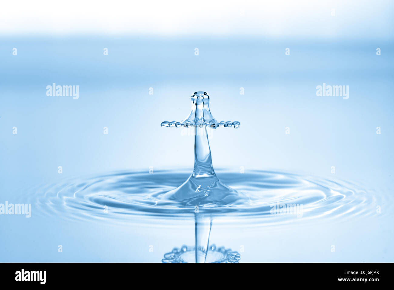 Water crown drop and splash on blue background Stock Photo - Alamy