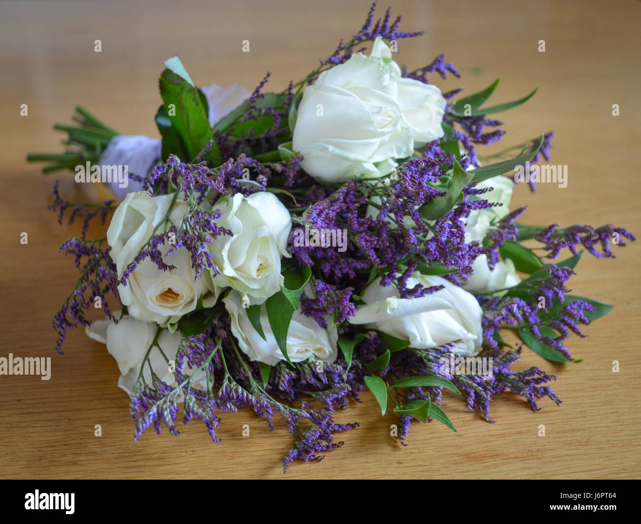 a bunch bouquet arrangement of white roses and mauve purple Limoniun ...