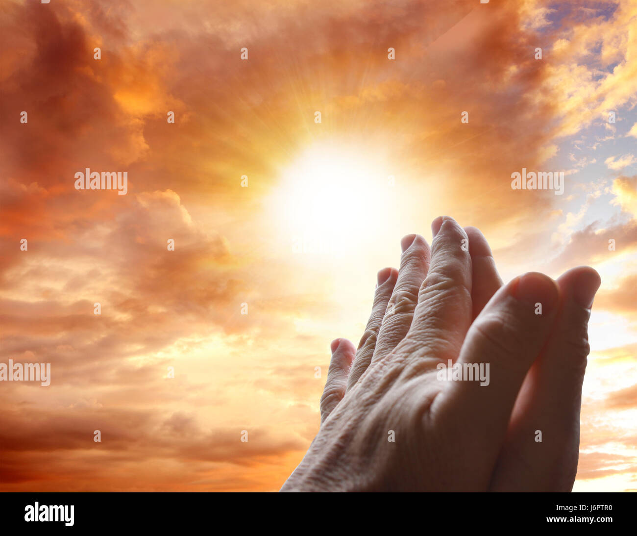 Hands together praying in bright sky Stock Photo - Alamy