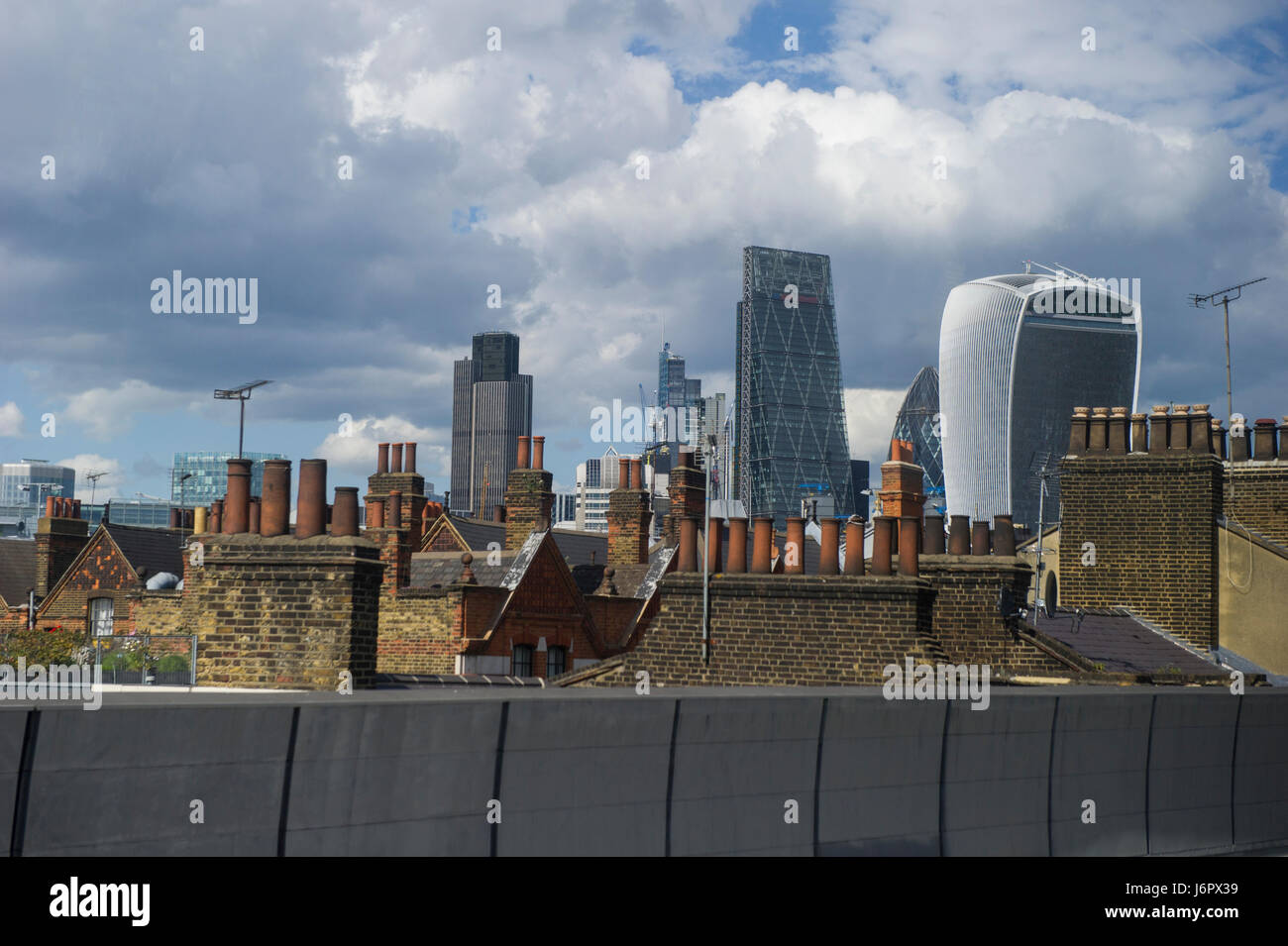 The City in the background with Victorian rooftops and chimneys in the ...